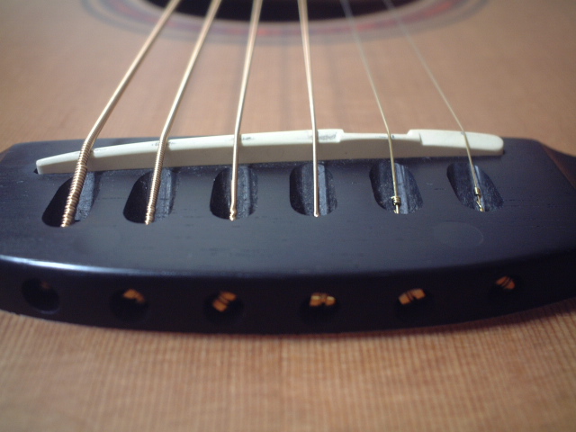 穴に弦の先を入れて、引っ張り出す。